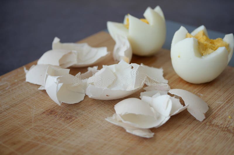 Broken Eggshells Scattered on a Wooden Cutting Board in a Kitchen Stock ...