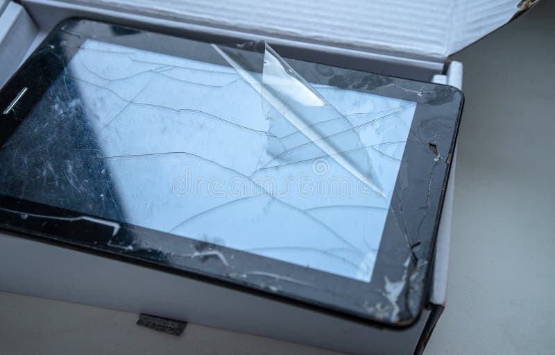 A Broken Electronic Tablet in a Cardboard Box, Cracks on the Screen ...