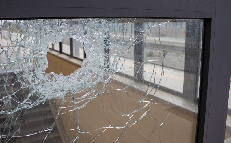 Broken Facade Window Glass. a Hole in the Window Glass from a Bullet ...