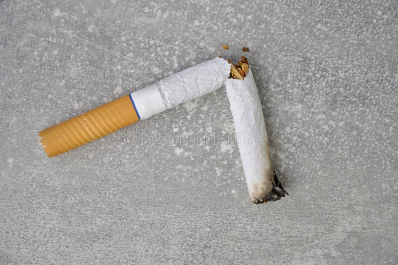 Broken in Half, Extinguished Cigarette on Gray, Concrete Floor, Closeup ...