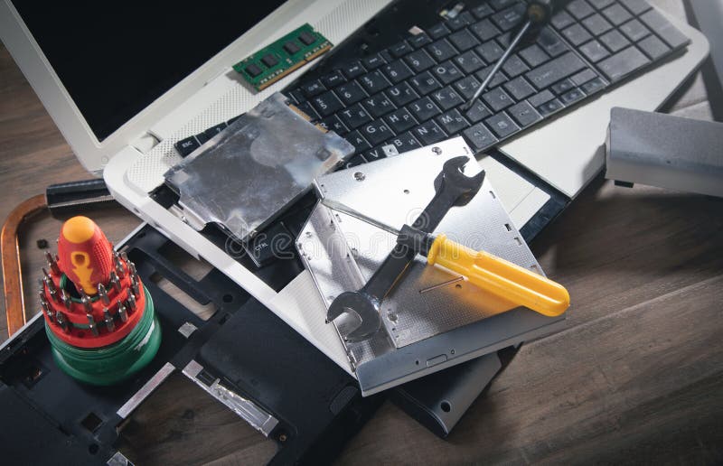Broken Laptop with a Wrench and Screwdriver on the Table. Computer ...