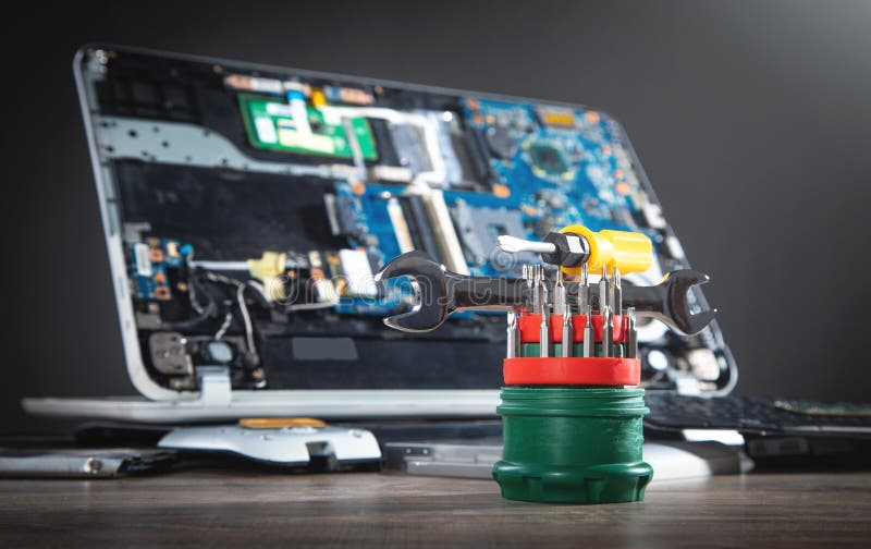Broken Laptop with a Wrench and Screwdriver on the Table. Computer ...
