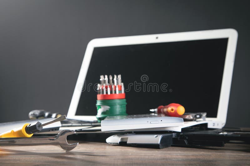 Broken Laptop with a Wrench and Screwdriver on the Table. Computer ...
