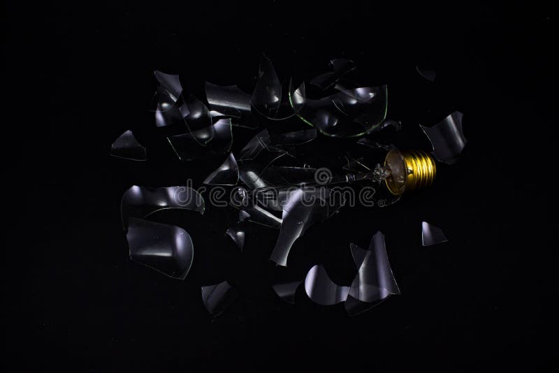 Broken Light Bulb on Dark Surface with Pieces Backlit Stock Image ...