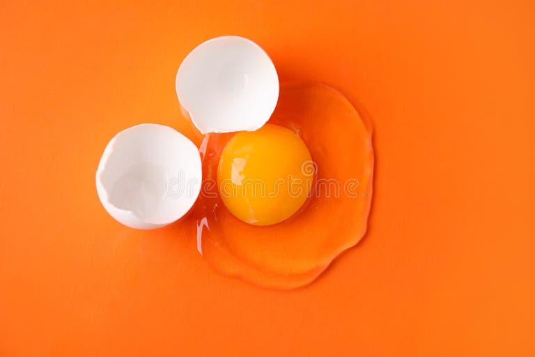 Broken Raw Egg and Shell on Orange Background, Top View Stock Photo ...