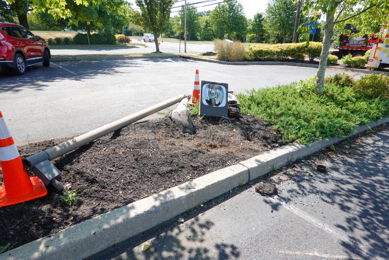 A Broken Street Light Lays on the Ground with Orange Warning Cones ...