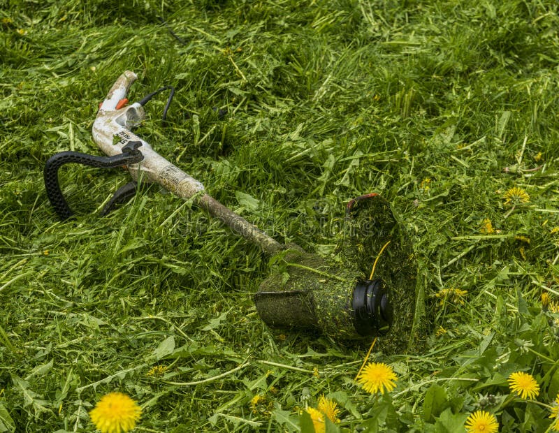 A Broken Trimmer is Lying in the Grass Stock Photo - Image of trim ...