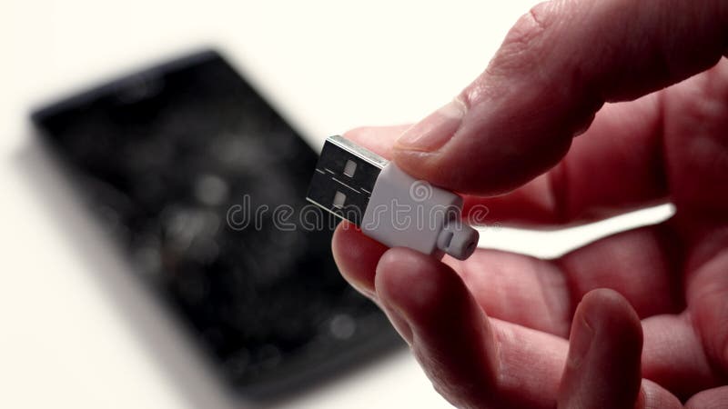 Broken USB Plug Torn from the Cable with a Smartphone on a White ...
