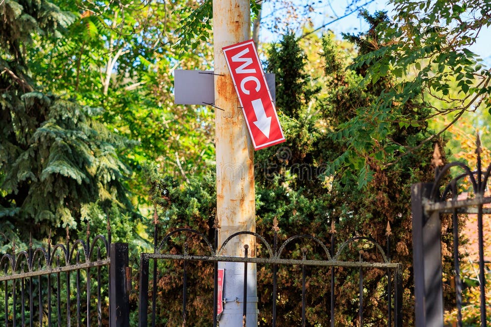 A Broken WC Sign Points Down a Pillar. Background with Selective Focus ...