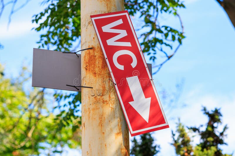 A Broken WC Sign Points Down a Pillar. Background with Selective Focus ...