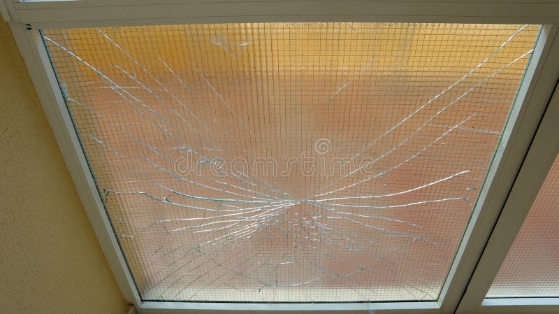 Broken Windowpane with Wire Mesh Behind it. Glass is Shattered with ...