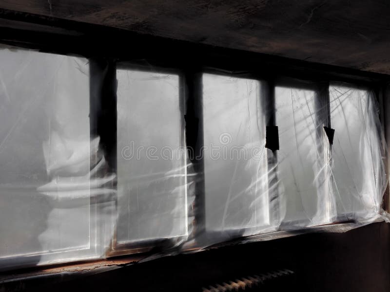 Broken Windows Covered with Plastic Nylon in Empty Room. Stock Image ...