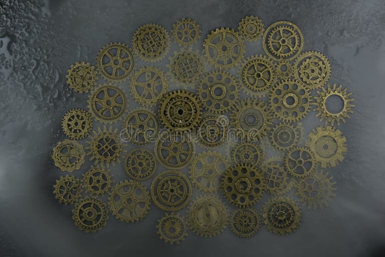 Bronze Cogs and Wheels Arranged on Slate Rock Background Showing ...