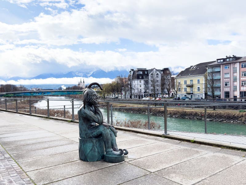 Bronze Statue of Sitting Man by River in Urban Landscape in Villach ...