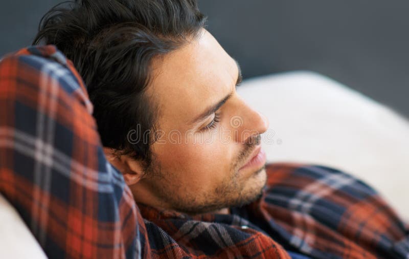 Brooding Good Looks. a Handsome Young Man Sitting on the Sofa at Home ...