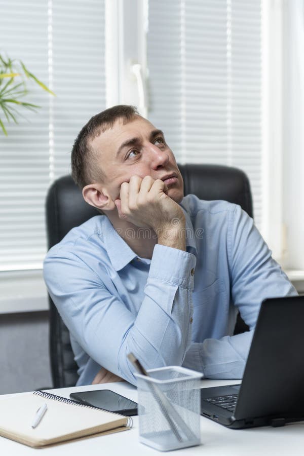 Brooding Young Man in the Office Behind the Workplace. Portrait of an ...