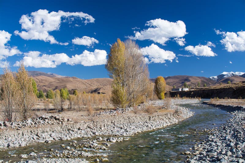 Brook with Trees in Autumn and Mountains with Blue Sky Background Stock ...