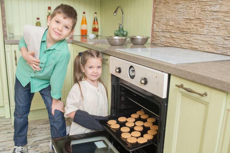 Brother and Sister Baking Cookies in the Oven in the Kitchen Stock ...