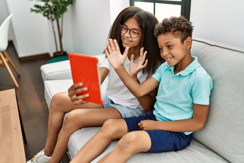 Brother and Sister Having Video Call Using Touchpad Sitting on Sofa at ...
