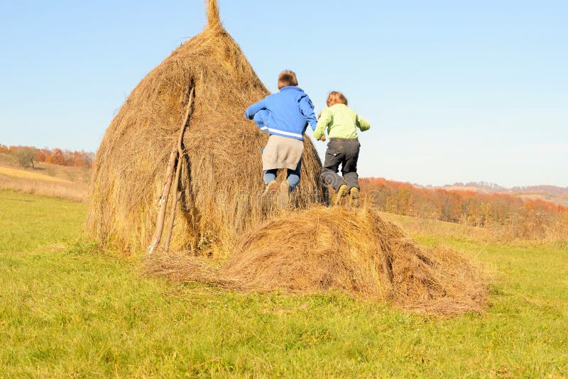 Brother and Sister Jumping on a Haystack Stock Image - Image of ...