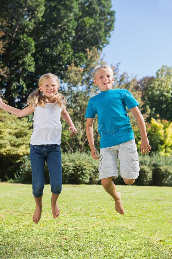 Brother and Sister Jumping Together Stock Image - Image of child ...
