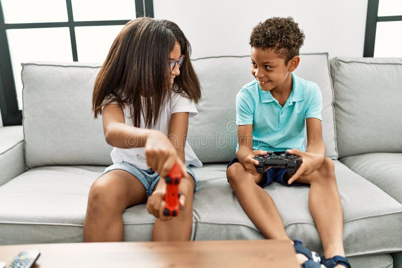Brother and Sister Playing Video Game Sitting on Sofa at Home Stock ...