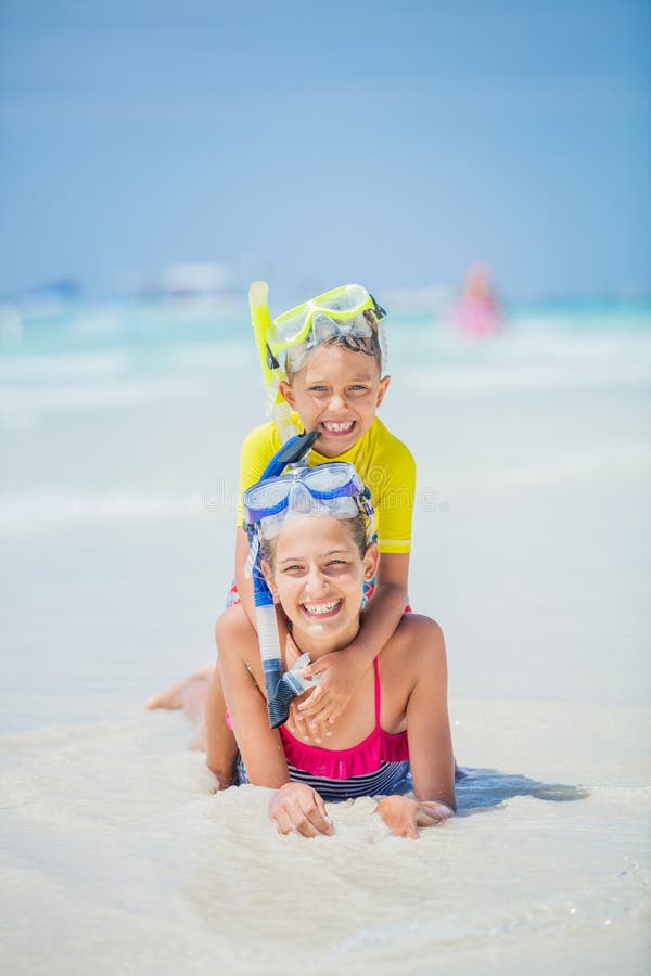 Brother And Sister In Scuba Masks Playing On The Beach During The Hot Summer Vacation Day Stock