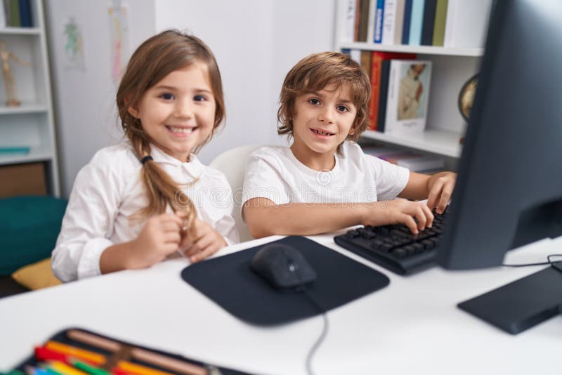 Brother and Sister Students Using Computer Sitting on Table at ...