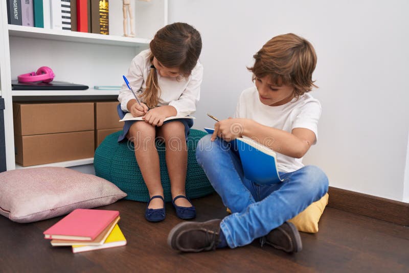 Brother and Sister Students Writing on Notebook Studying at Library ...