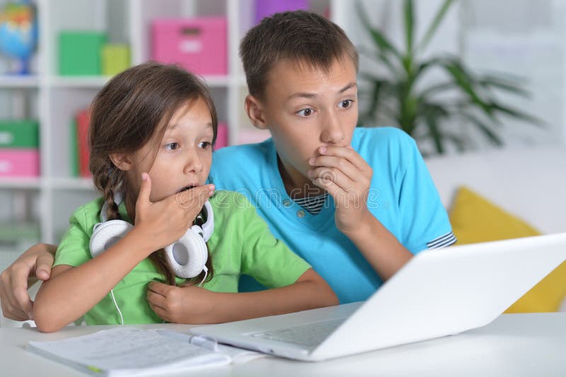 Brother and Sister Using Laptop while Sitting at Table Stock Photo ...