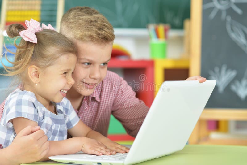 Brother and Sister Using Laptop White Sitting at Table Stock Photo ...