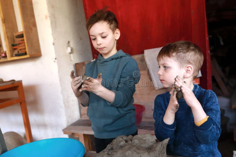 Brothers make clay crafts stock image. Image of artist - 148061471