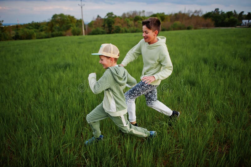 Brothers Running and Having Fun Together at Meadow Stock Photo - Image ...
