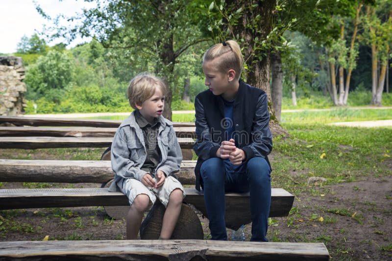 Brothers sit on a bench stock image. Image of family - 103380533