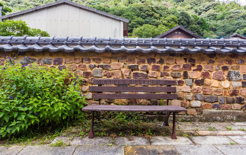 Brown Bench Against Retro Japanese Style Brick Wall Stock Photo - Image ...