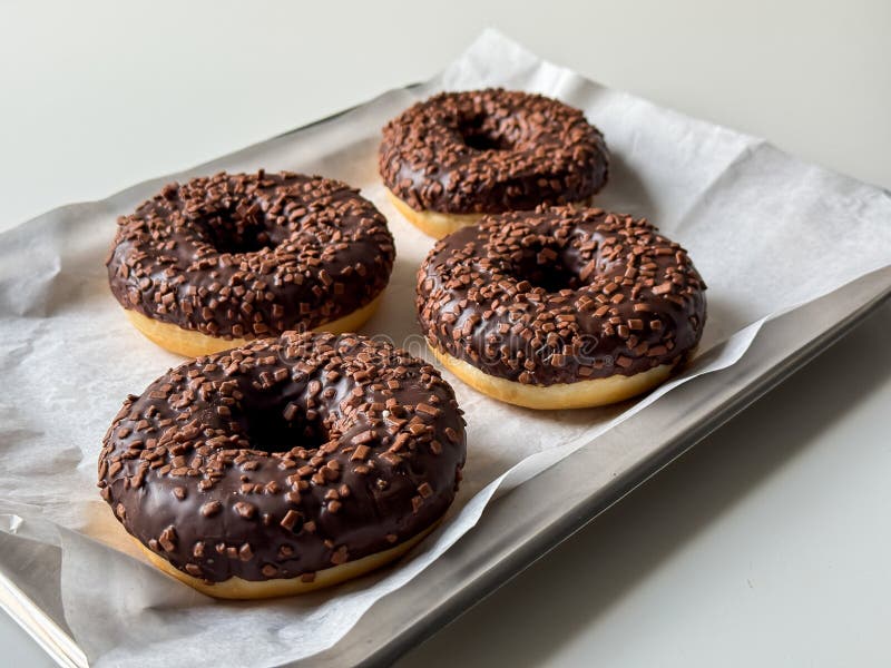 Brown Chocolate Donuts on Metal Tray and White Table Side View Stock ...