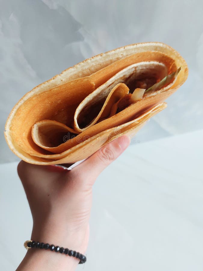 A brown crepe in his hand stock image. Image of chopped - 344948461