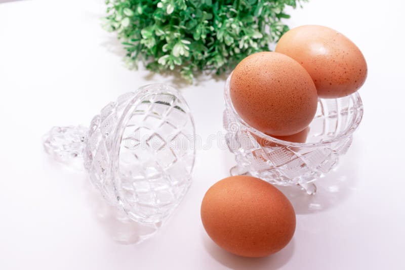 Brown Easter Eggs in Crystal Bowl with Spring Plant on a White Table ...