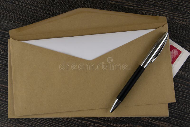 Brown Envelope, Pen and Stamps on Wooden Table Editorial Image - Image ...