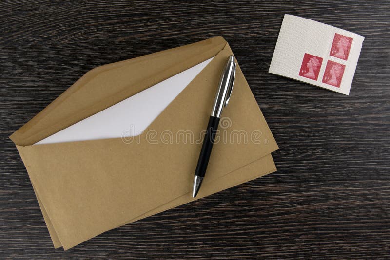 Brown Envelope, Pen and Stamps on Wooden Table Editorial Stock Image ...