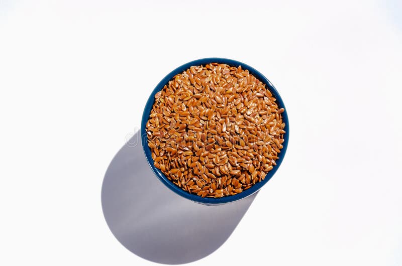 Brown Flax Seeds In Blue Ceramic Bowl On White Background Stock Image