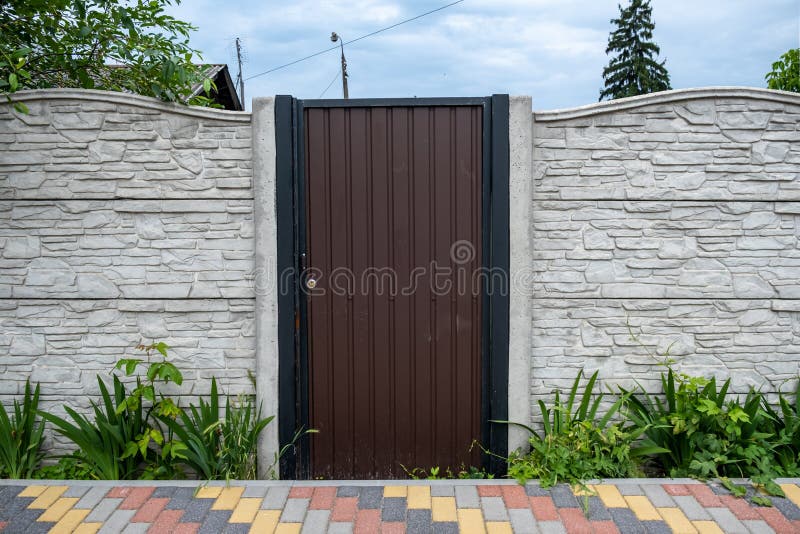 The Brown Gate of Corrugated Iron between the Concrete Slabs of the ...
