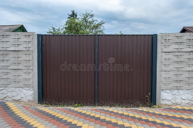 The Brown Gate of Corrugated Iron between the Concrete Slabs of the ...