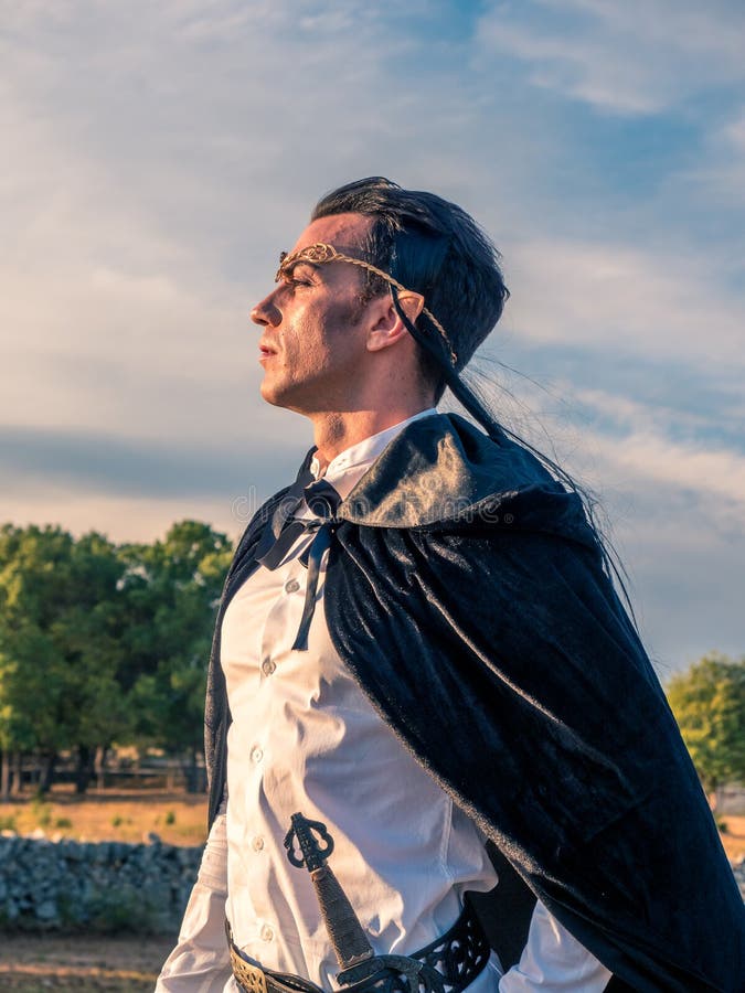 Brown-haired Man with Elf Ears, Tiara on Head and Black Cape, Looks ...