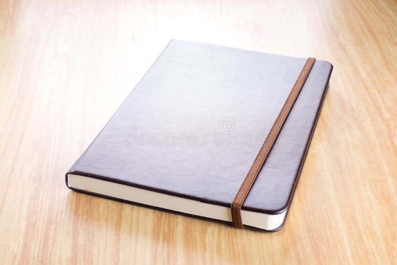 Brown Hard Cover Notebook with Elastic Strap on Wooden Table in Stock ...