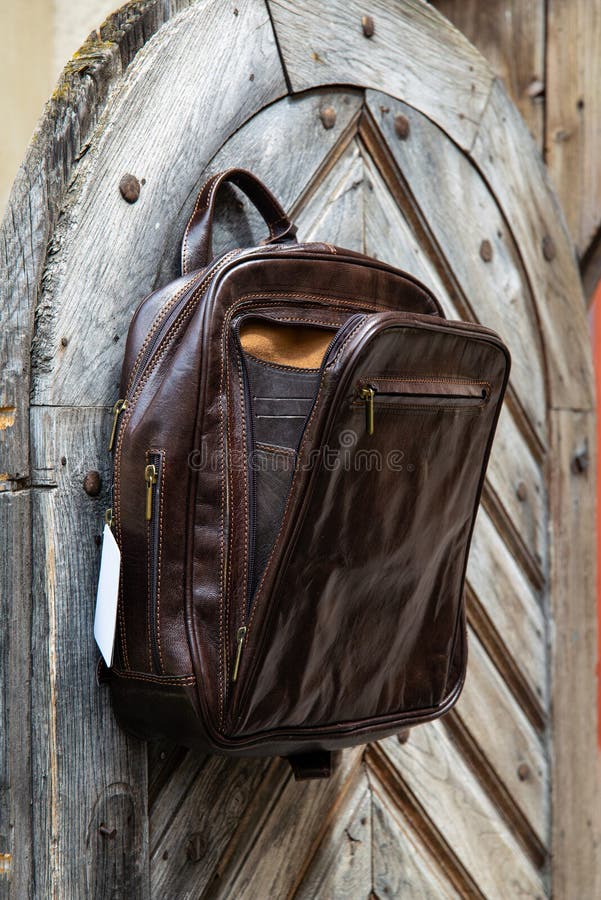 Brown Leather Backpack on the Wooden Door Stock Image - Image of ...