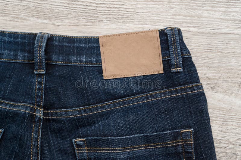 Brown Leather Label of Blue Jeans on Back of Jean with Wood Background ...