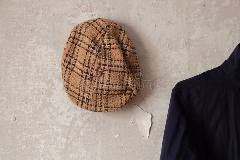 Brown Mens Cap in a Cage Hanging on the White Wall Stock Image - Image ...