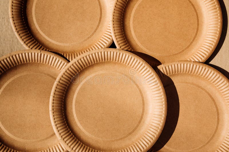 A Brown Paper Plates on a Brown Cardboard Background. Eco Friendly ...