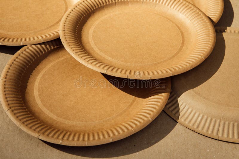 A Brown Paper Plates on a Brown Cardboard Background. Eco Friendly ...